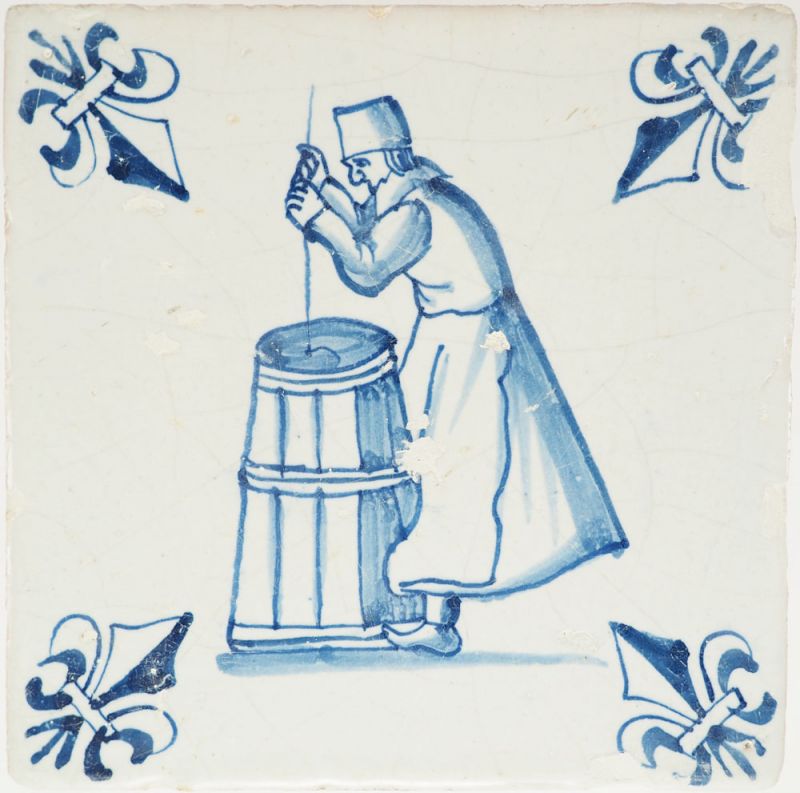 Antique Delft tile with a lady churning butter, 17th century